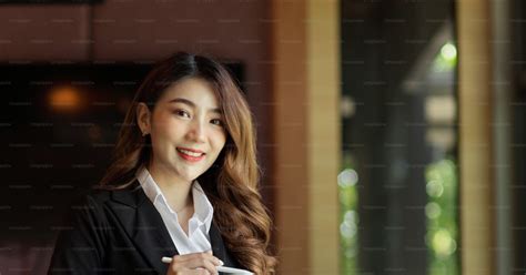 매력적인 비즈니스 여성이 사무실 책상에 앉아 태블릿 컴퓨터와 스타일러스 펜을 들고 있다 사진 Unsplash의 앉아 이미지