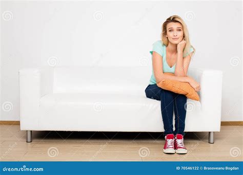 Blondine Die Auf Couch Mit Einem Kissen Sitzen Stockfoto Bild Von