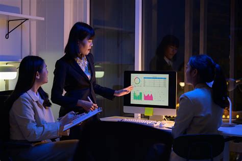 현대식 사무실에서 밤늦게까지 일하며 프로젝트를 공동 작업하고 컴퓨터 화면에 표시된 차트와 데이터를 분석하는 세 명의 젊은 아시아 사업가 25 29세에 대한 스톡 사진 및