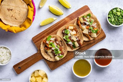돼지 고기 토르티야 파인애플 실란트로 양파 녹색 소스 레드 소스 레몬으로 준비 타코 알 목사라는 전통적인 멕시코 길거리 음식 흰색 텍스처 배경에 타코에 대한 스톡 사진 및