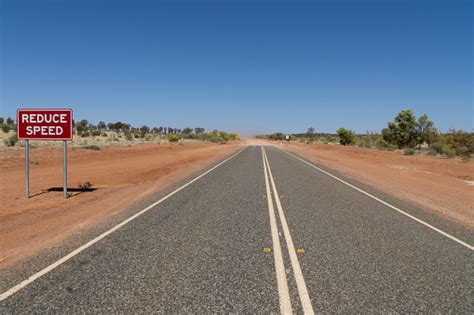 호주 아웃백의 고속도로에는 속도 감소 비문이 새겨진 빨간색 표지판이 있습니다 0명에 대한 스톡 사진 및 기타 이미지 0명