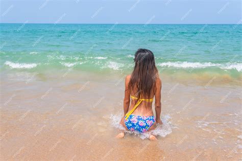 Premium Photo Rear View Of Woman Wearing Bikini Kneeling On Shore At