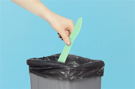 플라스틱 칼을 쓰레기통에 버리고 쓰레기통 앞에서 일회용 칼을 손에 들고 플라스틱 재활용 개념 개념에 대한 스톡 사진 및 기타 이미지 Istock