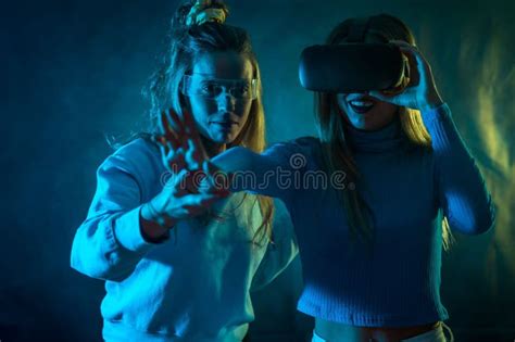 females wearing virtual reality glasses in a dimly lit room exploring