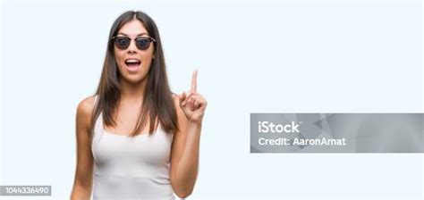 젊은 아름 다운 히스패닉 성공적인 아이디어와 손가락 가리키는 선글라스를 착용 종료 하 고 행복 번호 하나입니다 가리키기에 대한 스톡 사진 및 기타 이미지 Istock