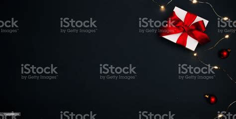 겨울 배너 흰색 선물 빨간 활 빨간 공과 인사말 카드에 대한 어두운 배경에 Xmas 장식에 반짝이는 조명 화환화 평평한 평지 상단 보기 복사 공간 검은색에 대한 스톡 사진