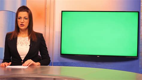 Female News Presenter In Broadcasting Studio With Green Screen Display For Mockup Usage Shot On