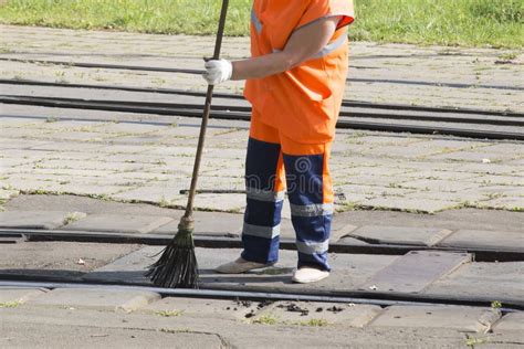 An Employee Of Municipal Services Is Engaged In Garbage Collection On The City Street Stock