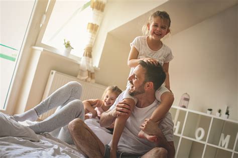 침대에 함께 재생 하는 명랑 한 가족 부모 그들의 딸과 함께 자유 시간을 보내고입니다 아버지 어깨에 앉아 어린 소녀입니다 3 명에 대한 스톡 사진 및 기타 이미지 Istock
