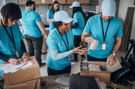 자선 푸드 뱅크에 기부 상자를 포장하는 다양한 자원 봉사자 Giving Tuesday에 대한 스톡 사진 및 기타 이미지 Giving Tuesday 고무장화 공동체