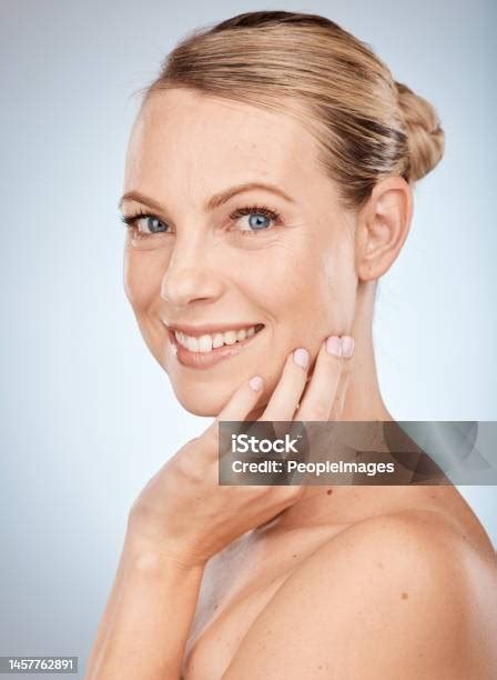 아름다움 스킨케어 및 천연 화장품 건강한 피부 및 화장품 피부과를 위한 얼굴에 손을 가진 여성 행복한 웰빙 모델 유기적인 얼굴 빛 회색 스튜디오 배경에 미소를 짓는 초상화