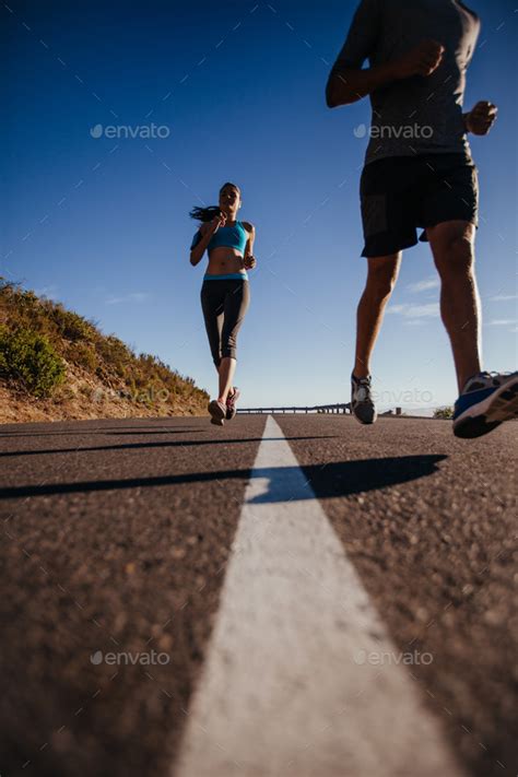 Woman Running On Road With Man In Front Stock Photo By Jacoblund PhotoDune