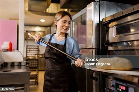 오븐에서 과자를 굽는 빵집 생산에서 일하는 제복을 입은 여성 제빵사 건강에 좋지 않은 음식에 대한 스톡 사진 및 기타 이미지 건강에 좋지 않은 음식 경영자 고용과