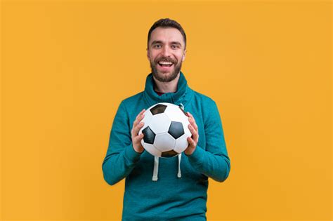 밝은 색깔의 노란색 배경에 손에 축구 공을 들고 웃고 포즈를 취하는 젊은 수염 노트북에 대한 스톡 사진 및 기타 이미지 노트북 놀기 축구 Istock