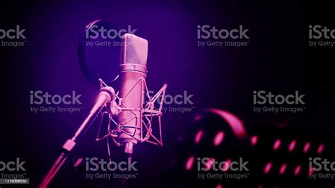 마이크 스탠드의 전문 마이크 및 진동 방지 사운드 스튜디오 프로덕션의 마이크 스튜디오에서 마이크와 쇼크 마운트 팝 필터를 클로즈업합니다 어두운 곳에 콘덴서 마이크를 설치하고