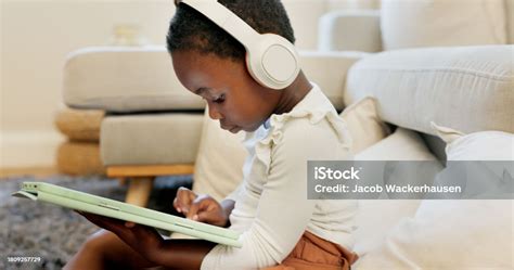 어린이 헤드폰 및 태블릿 학습 가정 및 교육용 게임 오디오 및 디지털 바닥 흑인 소녀 개발 및 온라인 읽기 스크롤 및 거실에서 기술 듣기 아이에 대한 스톡 사진 및 기타