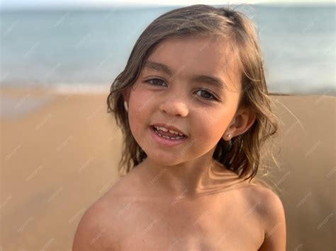 Portrait Of Smiling Shirtless Girl At Beach Premium Photo