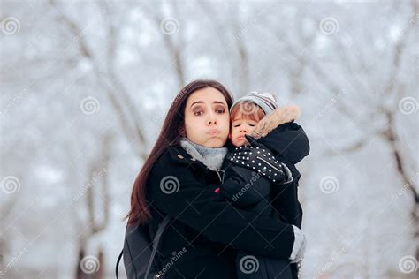 Mamá Estresada Sujetando A Una Niña En Tiempo Frío Imagen De Archivo