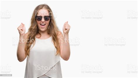 무기와 성공에 대 한 흥분된 선글라스를 착용 하는 젊은 금발의 여 자가 축 하 승리 미소 발생 합니다 우승자 개념입니다 곱슬 머리에 대한 스톡 사진 및 기타 이미지 Istock