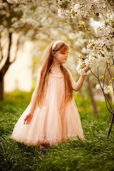 خرید و قیمت دانلود عکس با کیفیت دختر با لباس گلبهی در حال لذت بردن از گل های پاییزی ترب