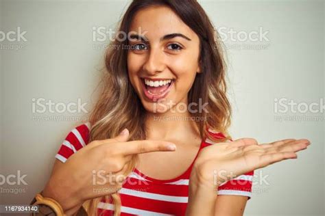 젊은 아름다운 여자 입고 빨간 줄무늬 T 셔츠 위에 흰색 고립 된 배경 매우 행복 가리키는 손과 손가락 T 셔츠에 대한 스톡 사진 및 기타 이미지 Istock