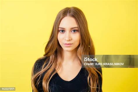 스튜디오에서 노란색 배경에 포즈를 취하는 긴 머리카락을 가진 젊고 아름다운 매력적인 귀여운 여학생 십대 모델의 초상화 16 17 살에 대한 스톡 사진 및 기타 이미지