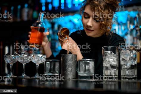 바에서 젊은 예쁜 여자는 금속 유리에 갈색 알코올 음료를 부어 각얼음에 대한 스톡 사진 및 기타 이미지 각얼음 갈색 강철