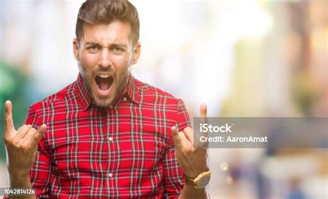 잘생긴 젊은이 손으로 바위 상징을 하 고 미친 표정으로 소리 고립 된 배경 위에 음악 스타입니다 무거운 개념입니다 개념에 대한 스톡 사진 및 기타 이미지 Istock