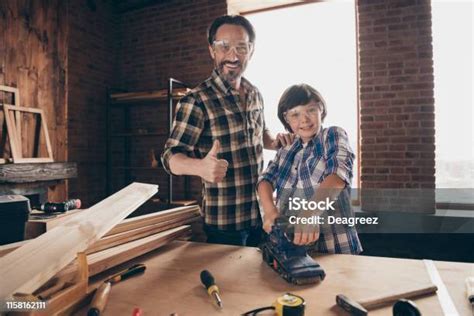 두 멋진 똑똑한 쾌활한 창조적 인 사람 마스터 아빠 아들의 초상화 는 현대 로프트 산업 벽돌 실내 실내에서 엄지 손가락을 보여주는 구식 흥미로운 직업 직업 아들에 대한 스톡