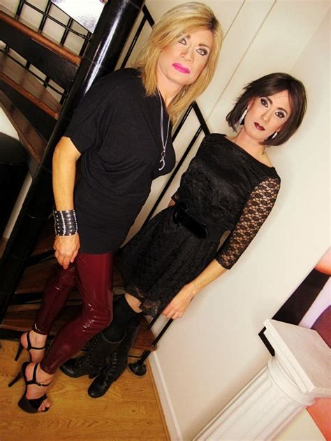 Two Women Standing Next To Each Other In Front Of A Stair Case With