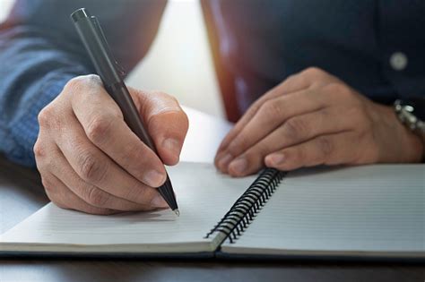 노트북 종이 나 편지에 필기 펜 메모를 사용하여 사람의 손을 클로즈업 테이블 데스크 사무실에 일기 학생 복사 공간이있는 작가를위한 직장 비즈니스 작업 및 학습 교육 개념