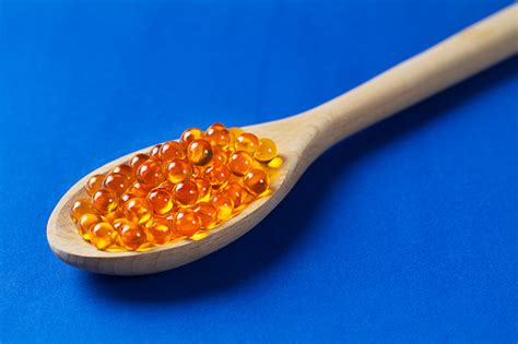 파란색 배경에 오메가 3 캡슐이있는 나무 숟가락 알약에 생선 기름 건강한 비타민과 치료 생물학적 활성 첨가제 복사 공간을 복사합니다 연어 해산물에 대한 스톡 사진 및 기타