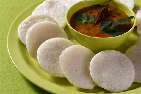 녹색 배경에 그릇에 삼바를 가진 이들리 인도 요리 남부 인도 좋아하는 음식 라바 Idli 또는 세몰리나 또는 라바 삼바와 녹색