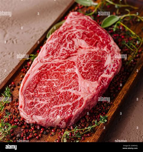 Raw Marbled Ribeye Steak Adorned With Herbs And Spices Ready For