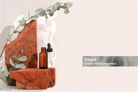 빨간 돌에 드롭퍼 세럼과 구겨진 종이와 베이지 색 배경으로 갈색 유리 병을 모으세요 잔인 공간을 복사합니다 산 성 박리 페이스