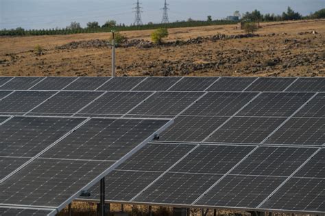 배경에 전력선이 있는 들판에 있는 태양 전지판의 줄 사진 Unsplash의 재생 에너지 이미지