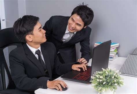 Premium Photo Two Business Man Laughing While Using Laptop Computer