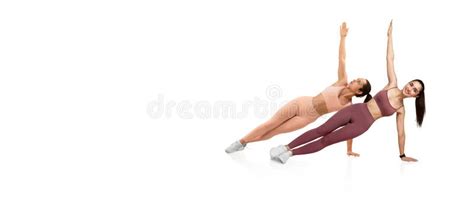 Two Women Performing A Synchronized Side Plank Exercise In Workout