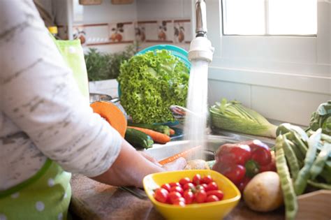 부엌의 코너입니다 노인의 손은 모든 종류의 야채를 청소합니다 채식주의자와 채식주의자를 위한 완벽한 음식 가정 주방에 대한 스톡