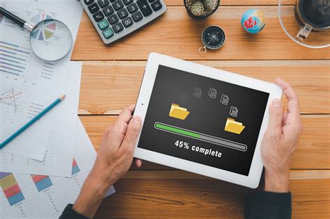 전송 파일 데이터 시스템 재배치 개념 가상 화면에로드 바 아이콘과 함께 전송 파일 프로세스를 기다리는 디지털 태블릿을 사용하는 사람의 손 0명에 대한 스톡 사진 및 기타