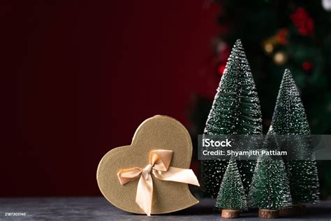 크리스마스 트리와 선물 상자의 아름 다운 크리스마스 휴일 프레임 테이블 표면에 황금 하트 모양의 선물 상자가있는 귀여운 새해 가문비 나무 0명에 대한 스톡 사진 및 기타