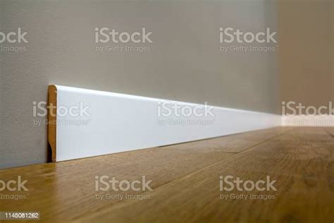 나무 또는 플라스틱 흰색 바닥 주 각 설치 나무 바닥과 흰색 석고 벽 배경에 큰 빈 방에서 내부 세부 사항 굽도리 널에 대한 스톡 사진 및 기타 이미지 Istock
