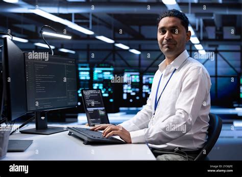 portrait of smiling engineer checking event logs on computer to find