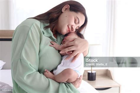 하얀 침실에서 사랑으로 갓 태어난 아기를 팔에 안고 있는 어머니 사랑스러운 가족 엄마와 아이가 함께 시간을 보내고 부모가 아이를 돌보고 출산 후 뚱뚱한 몸을 가진 과체중