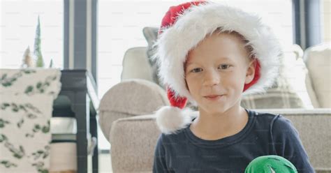 잠옷과 산타 모자를 쓰고 바닥에 앉아 있는 어린 소녀 사진 Unsplash의 꼬마 이미지