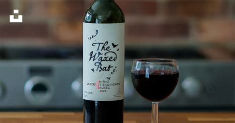 갈색 나무 테이블에 와인 잔 옆에 흰색 라벨이 붙은 병 사진 Unsplash의 무료 포도주 이미지