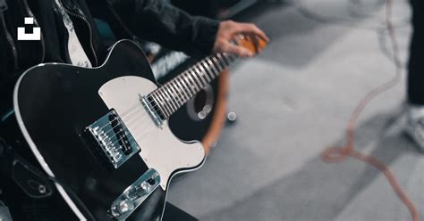 흰색 일렉트릭 기타를 연주하는 검은 재킷을 입은 남자 사진 Unsplash의 무료 하이브 룸 Surrey의 리허설