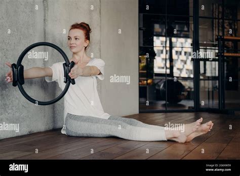Young Focused Redhead Woman Doing Strength Exercises With Pilates Ring