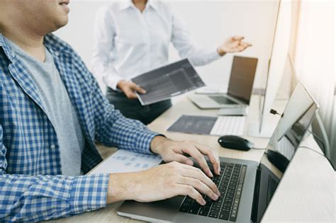 Two Software Developers Are Analyzing Together About The Code Written