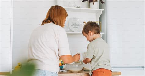 젊은 여자 어머니와 그녀의 유아 소년 아들은 집에서 밝은 부엌의 테이블에서 함께 요리한다 사진 Unsplash의 가족 이미지